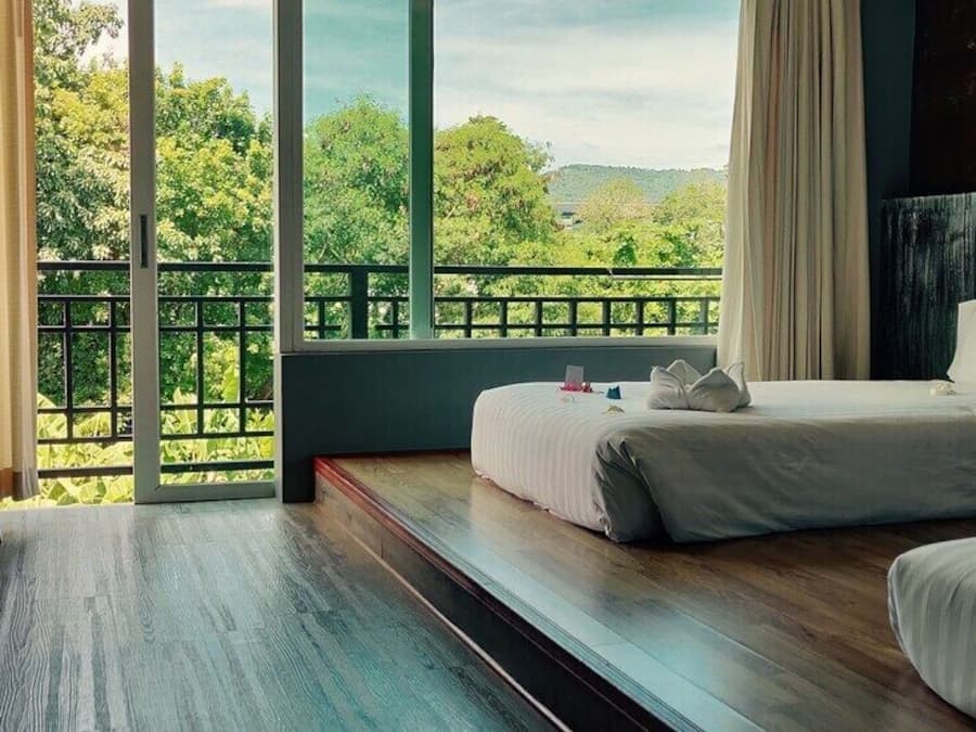 Quarto com duas camas e varanda, vista para o verde lá fora.