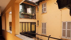 Um edifício com vários andares, varandas, escadas e guarda-corpo.