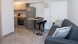 Uma cozinha moderna com geladeira, forno e banquetas de bar.