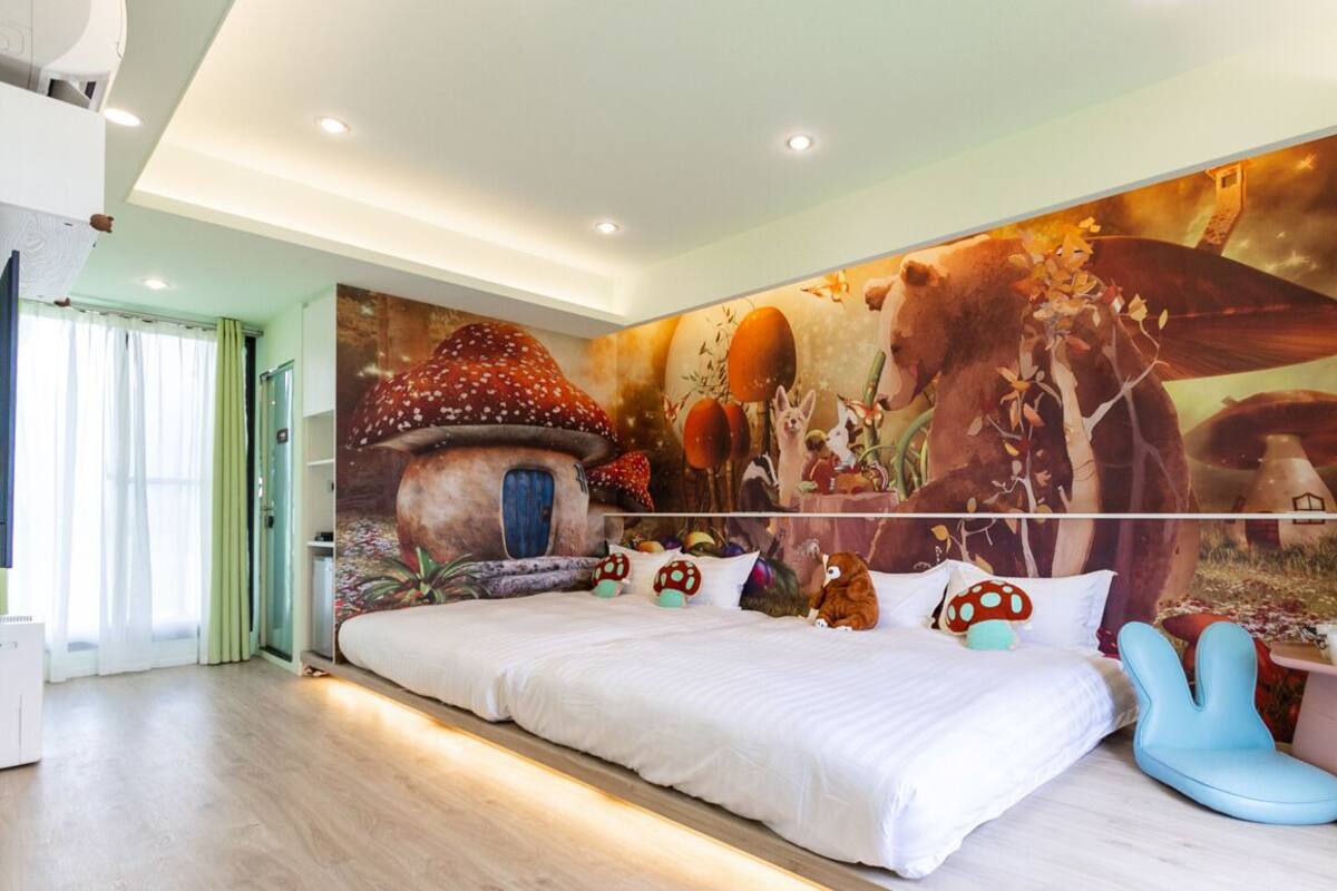 Quarto com um mural grande, uma cama com roupa de cama branca e uma pequena mesa com duas xícaras.