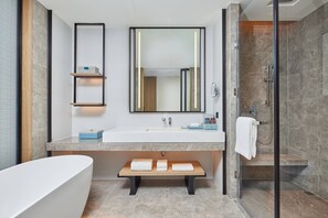 Um polibã e uma banheira separados, um chuveiro fixo