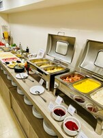 Buffet com diversos alimentos e acompanhamentos.