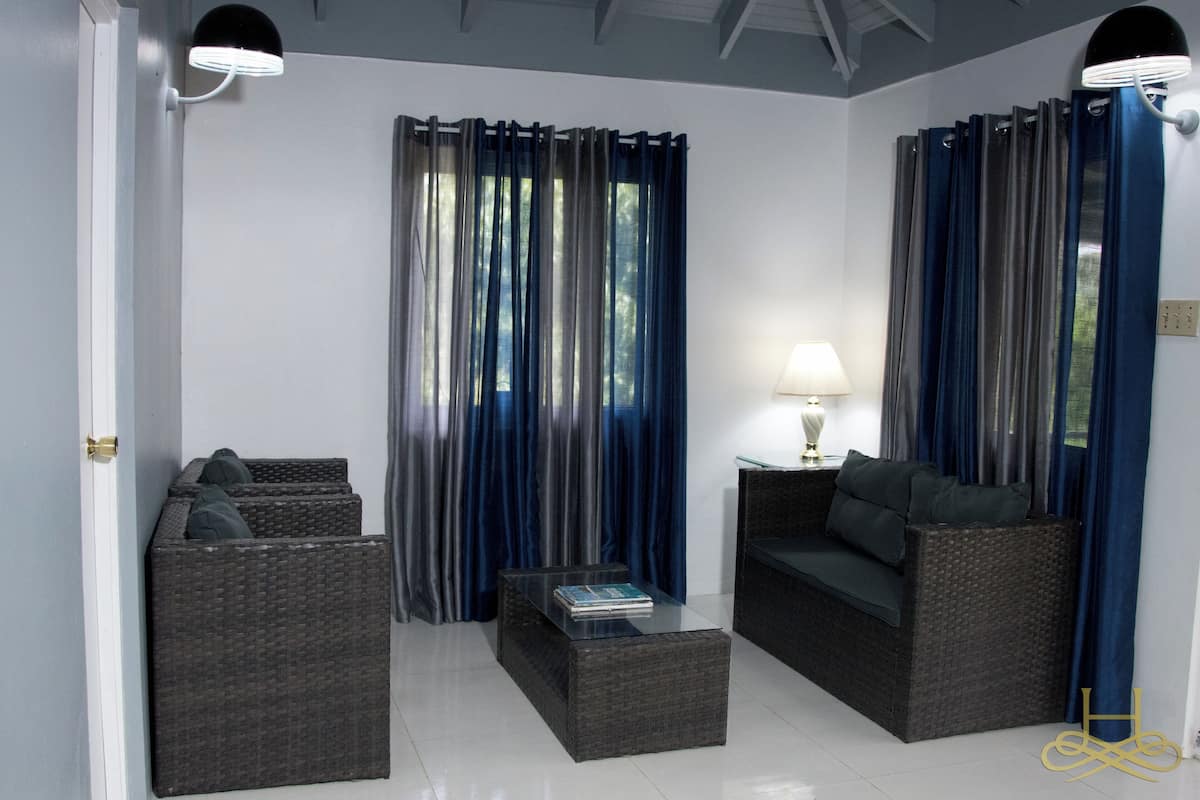 Uma sala de estar moderna com um sofá, uma mesa de centro e cortinas.