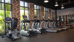Uma academia com esteiras, elípticos e bicicleta ergométrica.