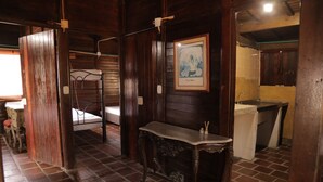 Um quarto rústico de madeira com uma cama, uma mesa e um quadro na parede.