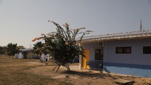 Um edifício térreo com telhado plano e um pequeno alpendre.