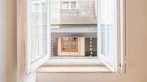 Visão através de uma janela aberta com uma porta de madeira e uma pequena janela acima.