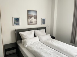 Cama bem arrumada com lençóis brancos em quarto de hotel.