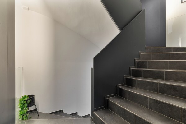 Escadaria moderna com degraus escuros e design minimalista.
