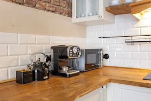 Uma cafeteira/bule, Minifrigorífico, um micro-ondas 