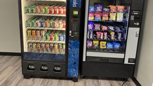 Duas máquinas de vendas automáticas com água, refrigerantes e lanches.