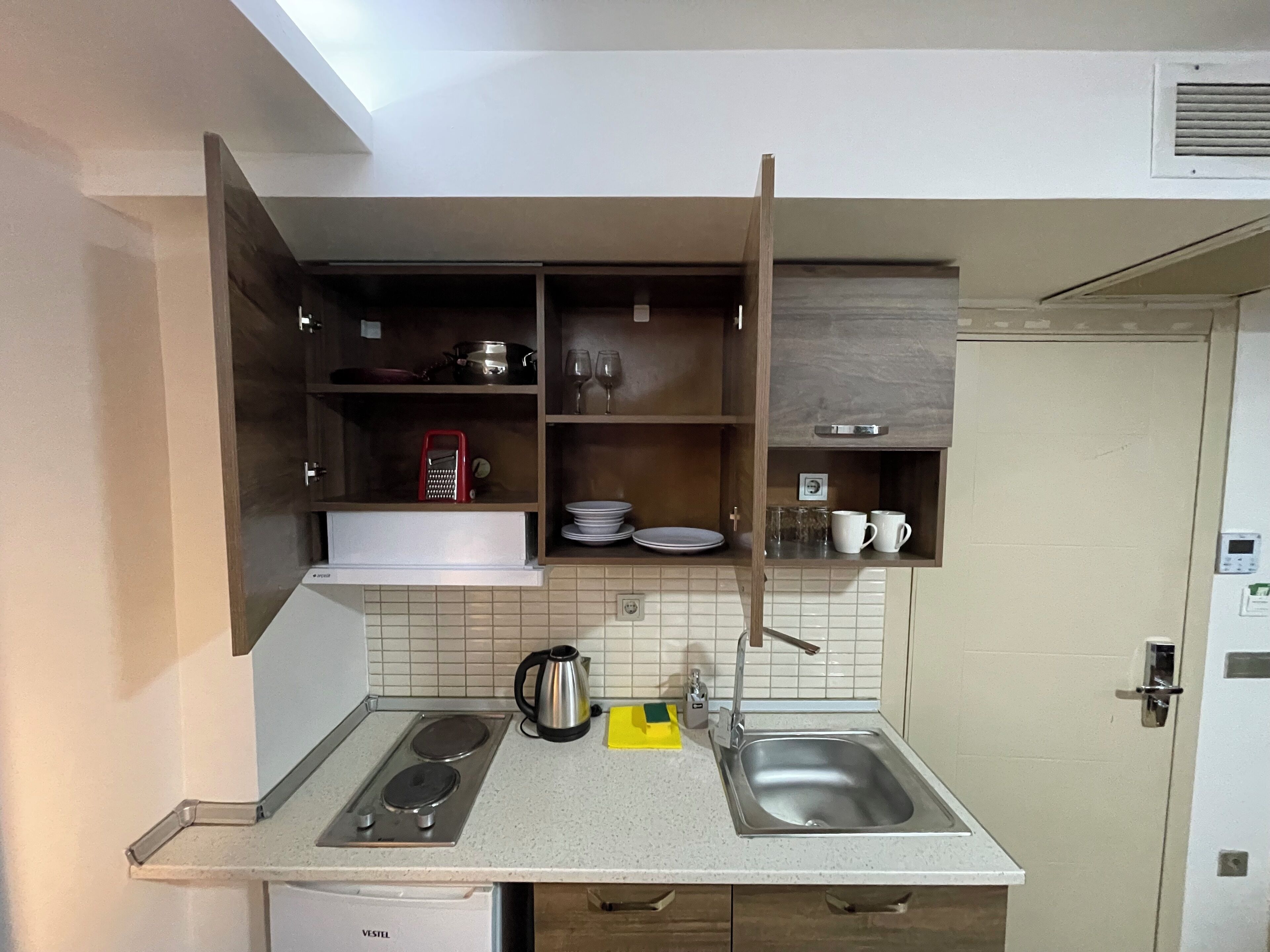 Uma cozinha compacta com fogão, pia e armários.