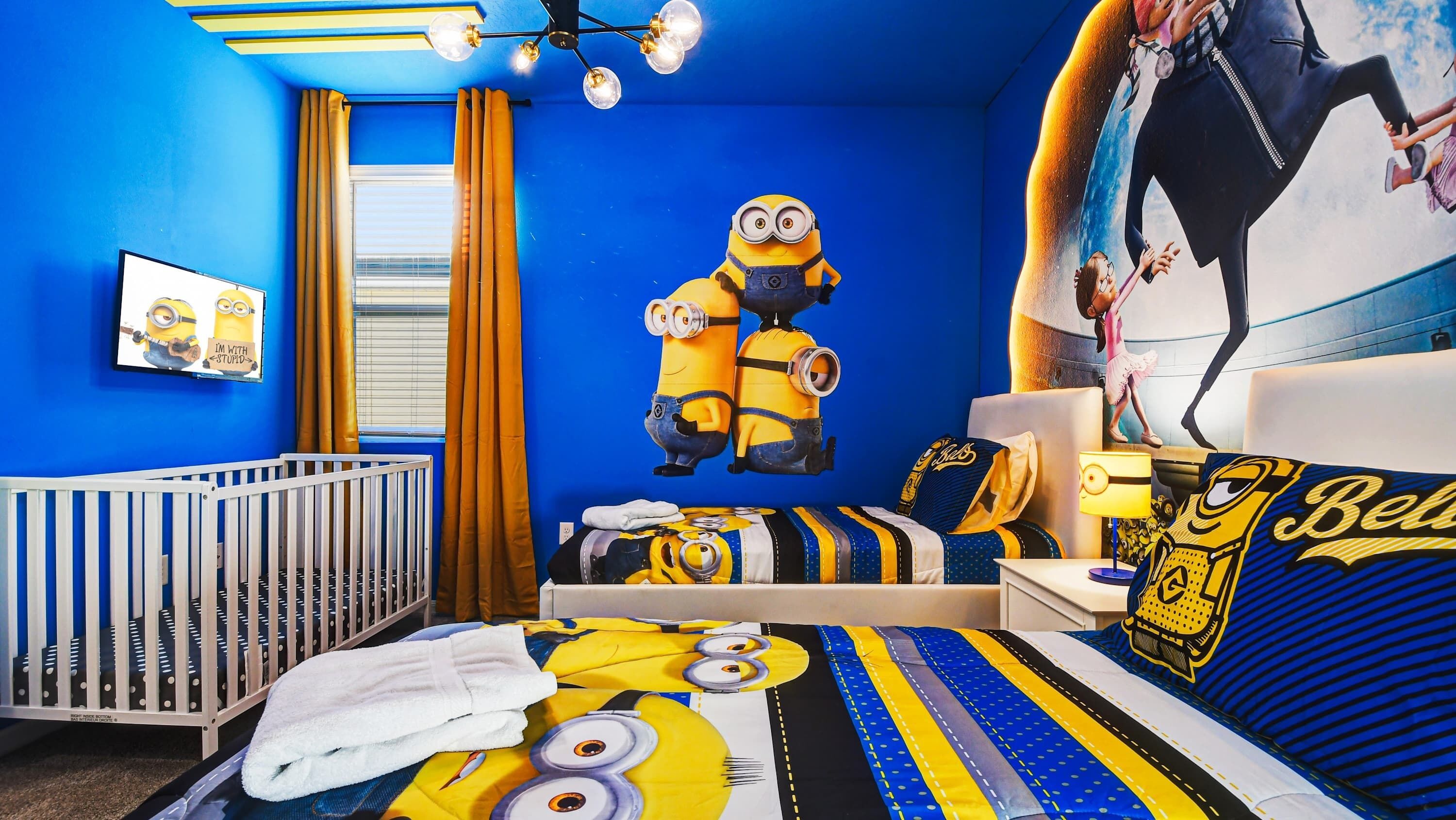 Quarto com parede azul, berço, cama com colcha temática de Minions e um grande mural de Minions na parede.