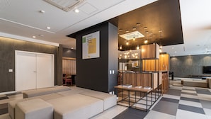 Um lobby moderno com área de estar, balcão de recepção e placa fixada na parede.