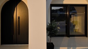 Um edifício moderno com uma grande porta de vidro e um vaso com planta.