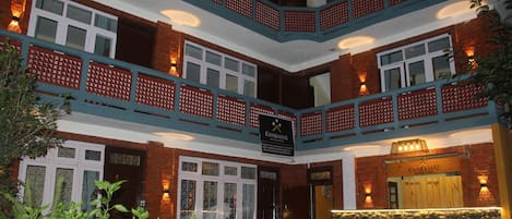 Um edifício de vários andares com uma placa com a inscrição "KWABAHAL" e um balcão de informações turísticas.