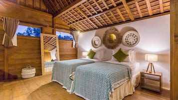 Um quarto acolhedor de madeira com duas camas, uma mesa pequena e uma mesinha de cabeceira.