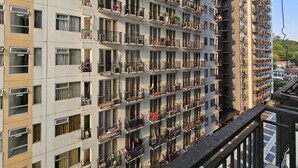Um edifício residencial alto com várias varandas, algumas com roupas penduradas, e uma placa visível de lavanderia.
