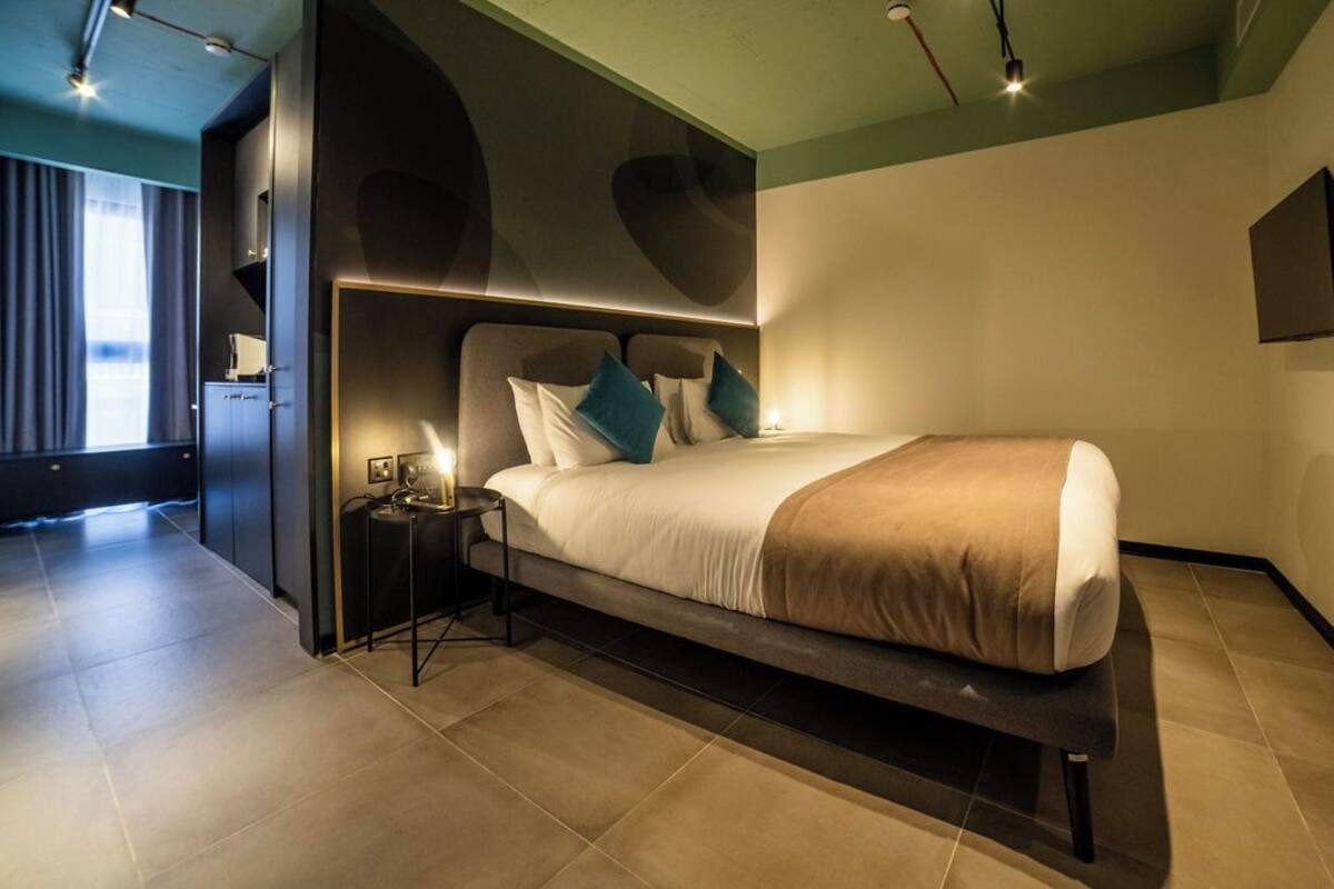 Um quarto moderno com uma cama grande, mesas de cabeceira e um guarda-roupa.