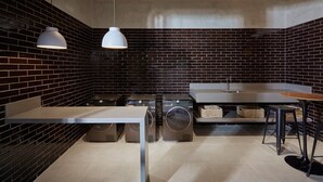 Uma cozinha moderna com painel de parede de tijolos, eletrodomésticos de aço inoxidável e iluminação pendente.