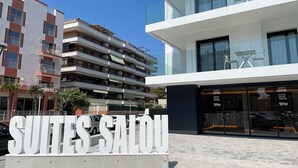 Um edifício moderno com uma placa que diz 'SUITES SALOU'.