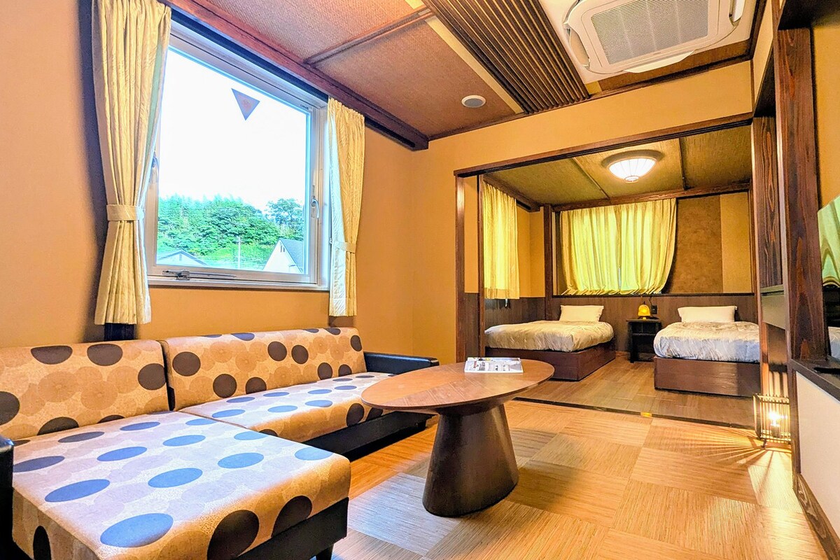 Quarto com sofá, mesa e beliche.