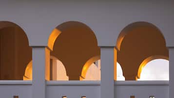 Um edifício com três grandes aberturas em arco, cada uma delas com uma pequena janela abaixo.