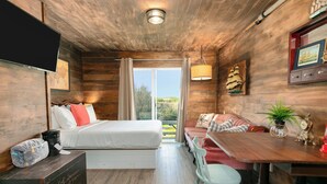 Um quarto aconchegante com cama, mesa de jantar e vista para o exterior.