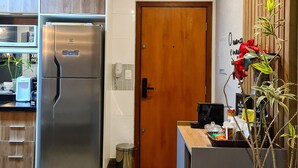 Uma cozinha moderna com geladeira de aço inoxidável, armários de madeira e uma porta de madeira.