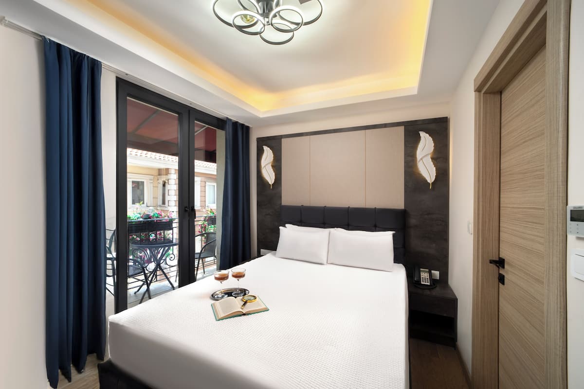 Quarto de hotel com uma cama grande, varanda com vista e luminária de teto moderna.