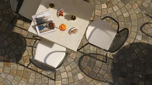Uma mesa com uma revista, um prato de comida e uma cadeira.