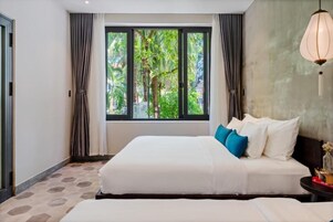 Quarto com cama grande, vista para o verde lá fora e luminária pendente.