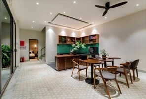Cozinha moderna com armários de madeira, área de jantar com mesa redonda e cadeiras, e ventilador de teto.