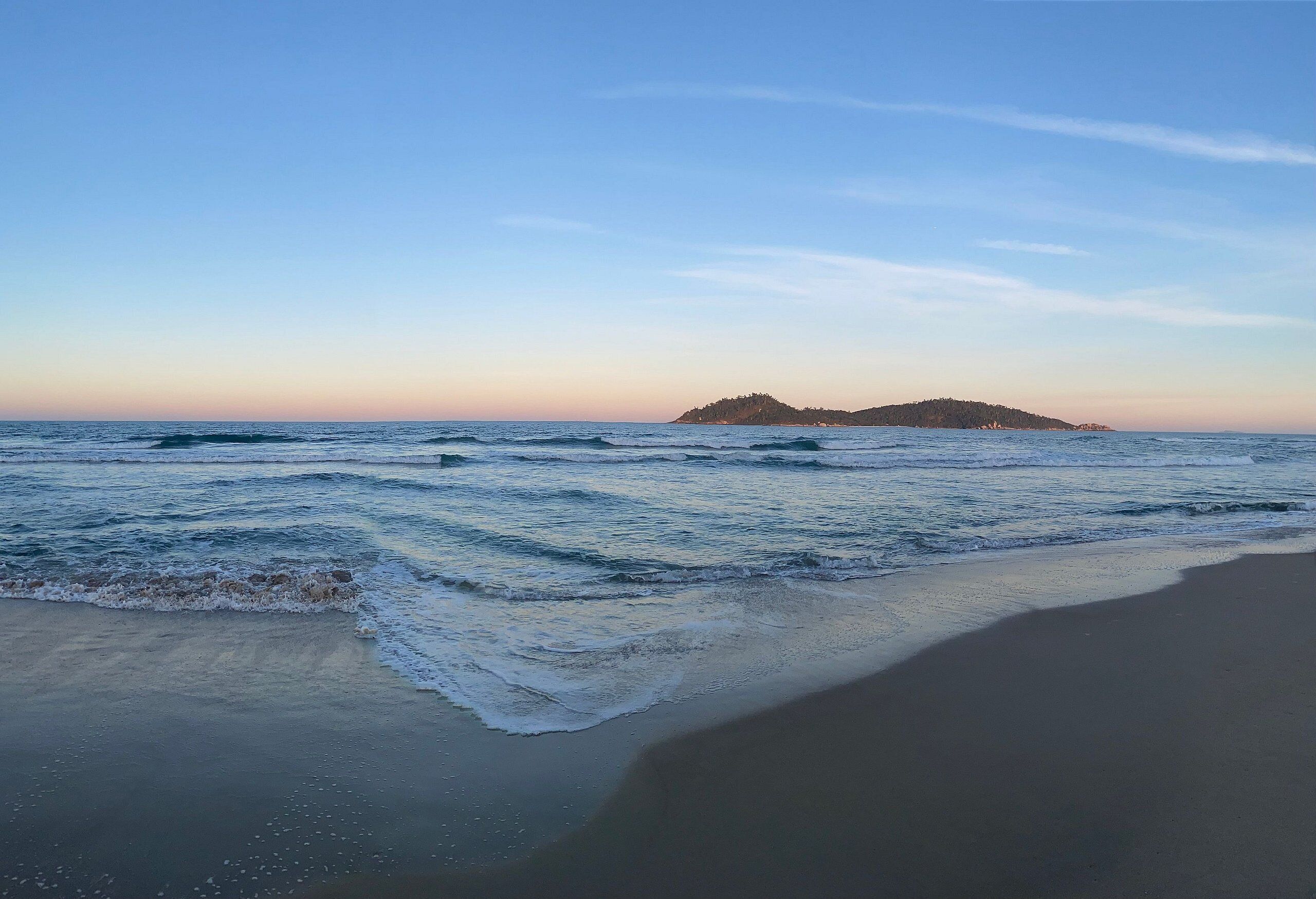 Perto da praia, areia branca, guarda-sóis 
