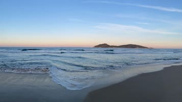 Perto da praia, areia branca, guarda-sóis