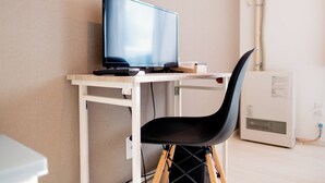 Um espaço de escritório moderno com escrivaninha, computador e cadeira.