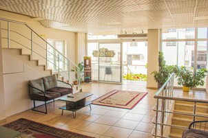 Uma sala de estar ampla com escada, sofá, mesa de centro e tapete.