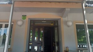 A entrada de um hostel e cafeteria chamado "O Camino", com uma placa com um personagem de desenho animado.