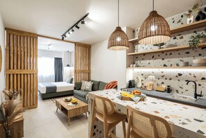 Um espaço de estar moderno e aberto, com cozinha, sala de jantar e um quarto.