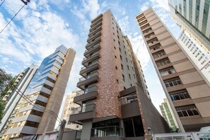 Um edifício alto com várias varandas e um design arquitetônico moderno.
