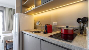 Cozinha moderna com fogão embutido, cafeteira e pia.