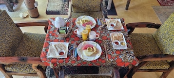 Mesa posta com pratos de comida, um bule e xícaras.