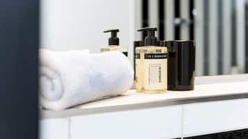 Um secador de cabelo, toalhas fornecidas, sabão, champô