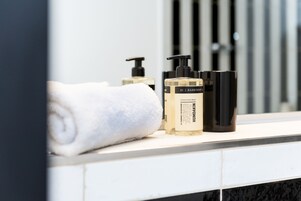 Um secador de cabelo, toalhas fornecidas, sabão, champô 