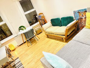 Uma sala de estar acolhedora com um sofá, uma mesinha e uma estante.