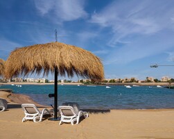 Praia particular, espreguiçadeiras, guarda-sóis, toalhas de praia