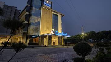 Um hotel Comfort Inn com fachada de vidro moderna, uma placa de destaque e área de entrada pavimentada.