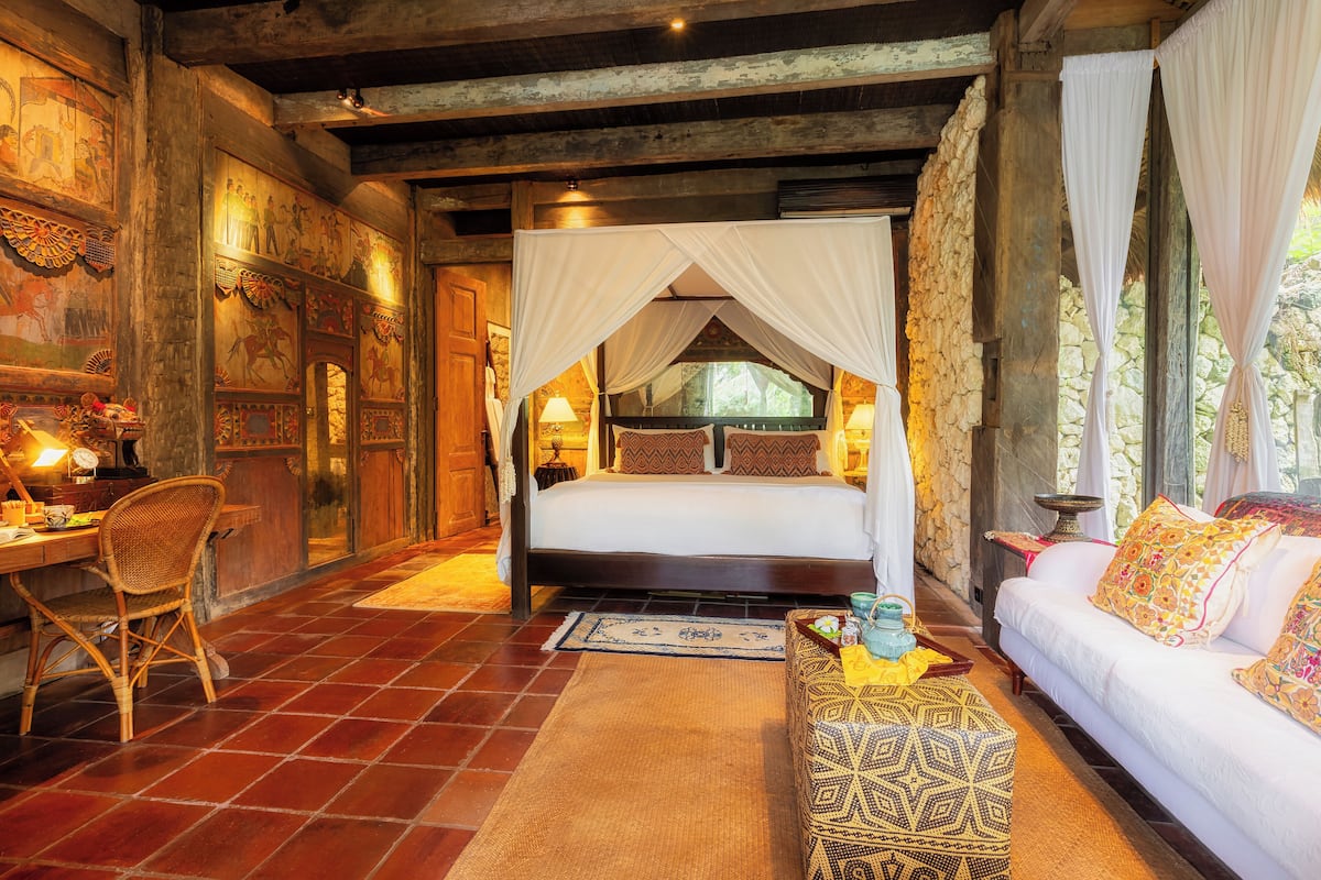 Quarto tradicional com cama, escrivaninha e sofá.