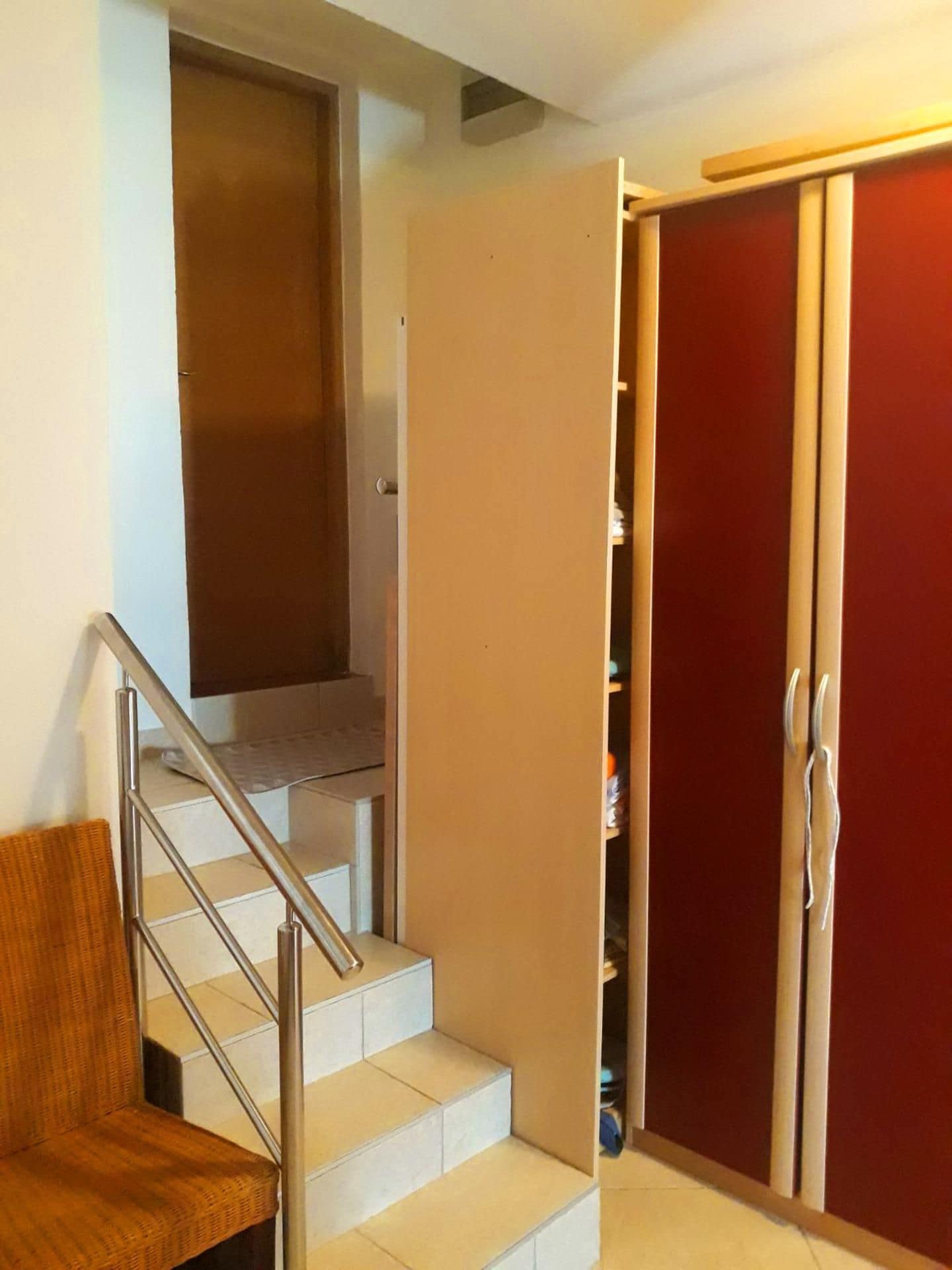 Uma escada com corrimão de metal que dá para um pequeno patamar.