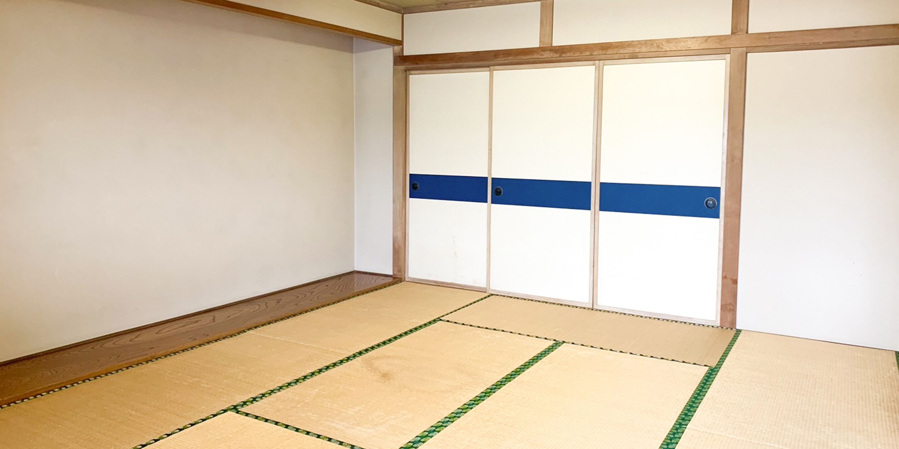 Quarto com piso de tatame, porta de tela shoji e teto de madeira.